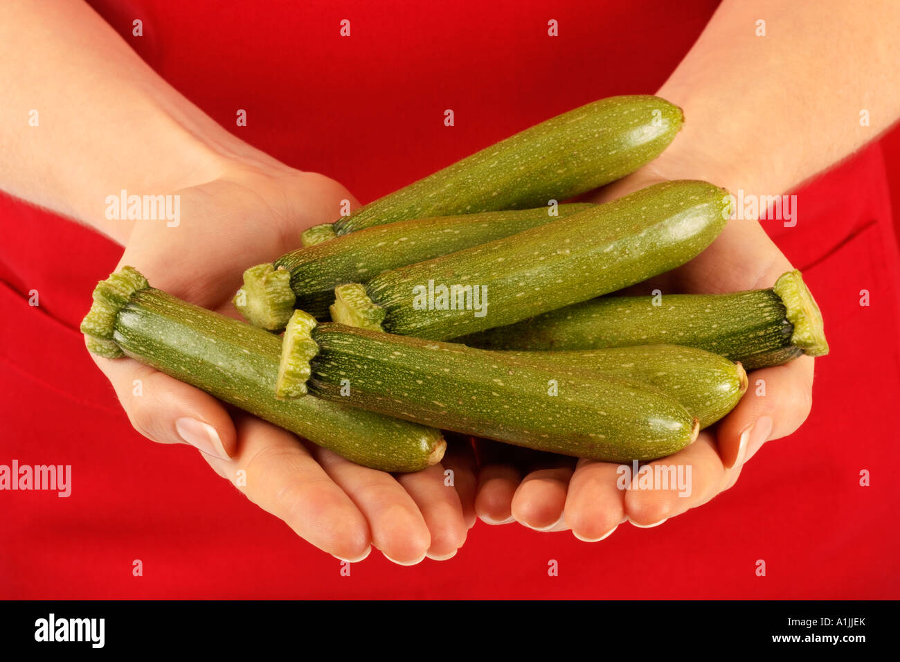 WOMAN HOLDING BABY COURGETTES / ZUCCHINI Stock Photo - Alamy