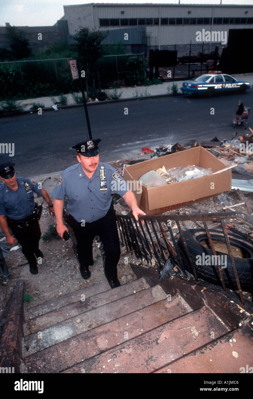 Police officers climb stairs to enter an abandoned building in the 75th ...