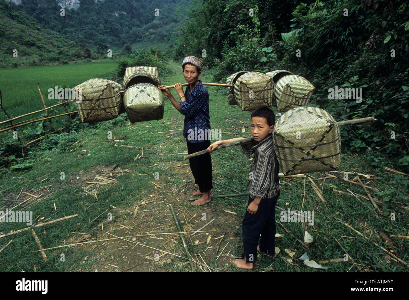 Na Hang Nature reserve, Vietnam. Tay woman and boy carrying hand woven ...
