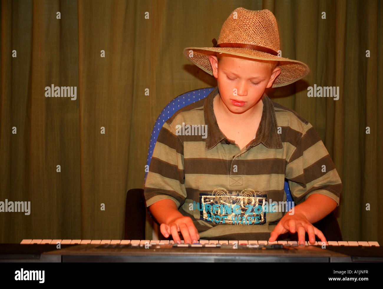 a young boy is playing on his Keyboard Stock Photo - Alamy