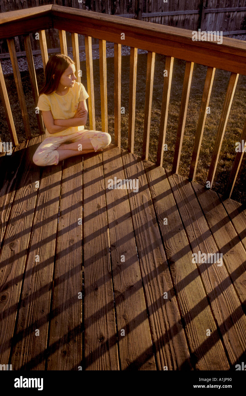 Young girl sitting on a backyard deck Stock Photo - Alamy