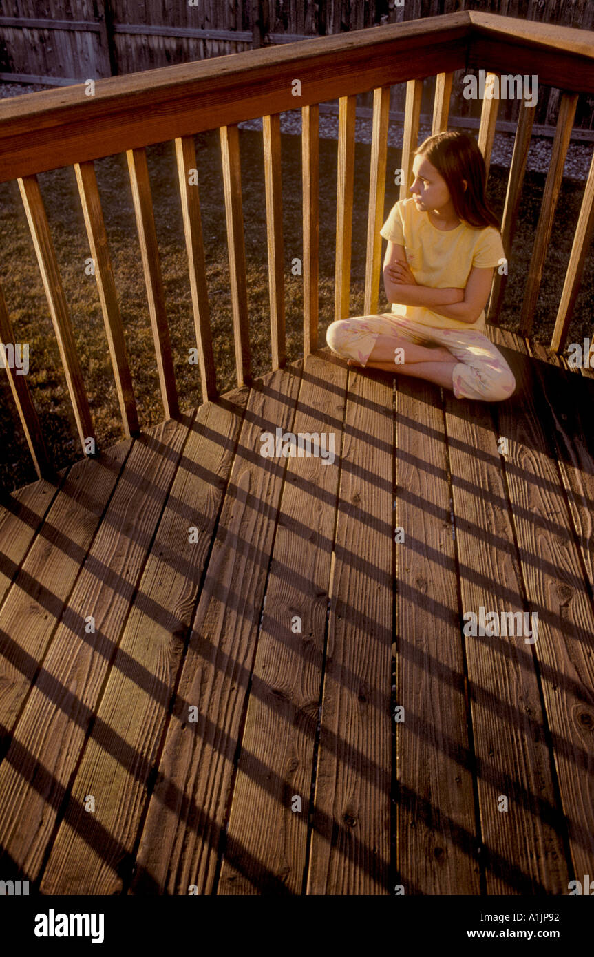 Young girl sitting on a backyard deck Stock Photo - Alamy