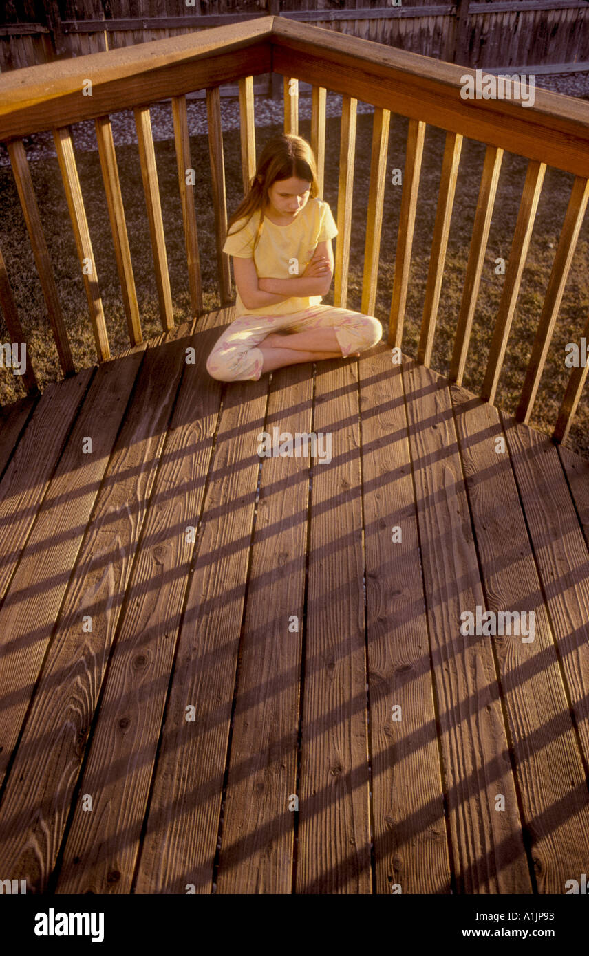 Young girl sitting on a backyard deck Stock Photo - Alamy
