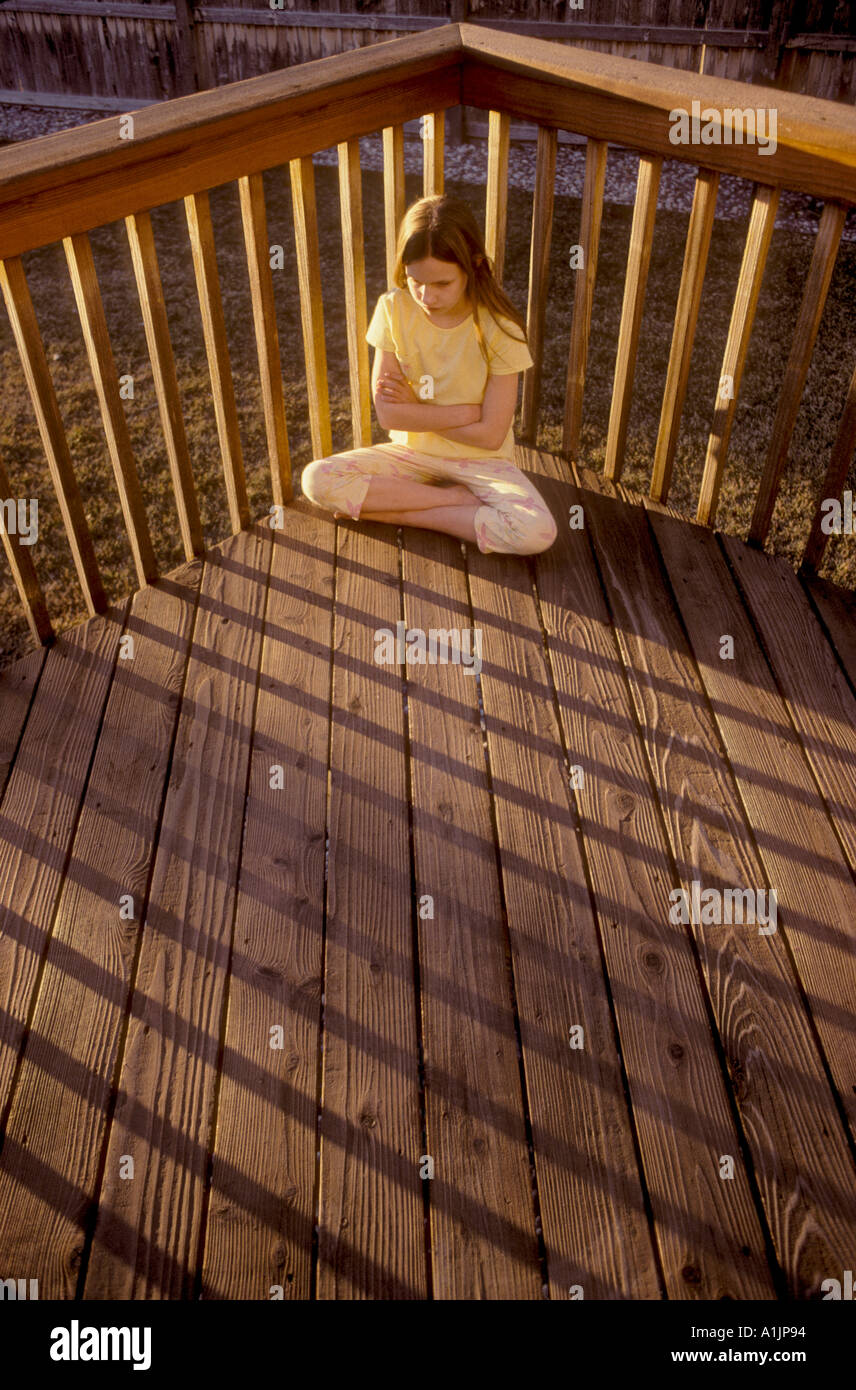 Young girl sitting on a backyard deck Stock Photo - Alamy