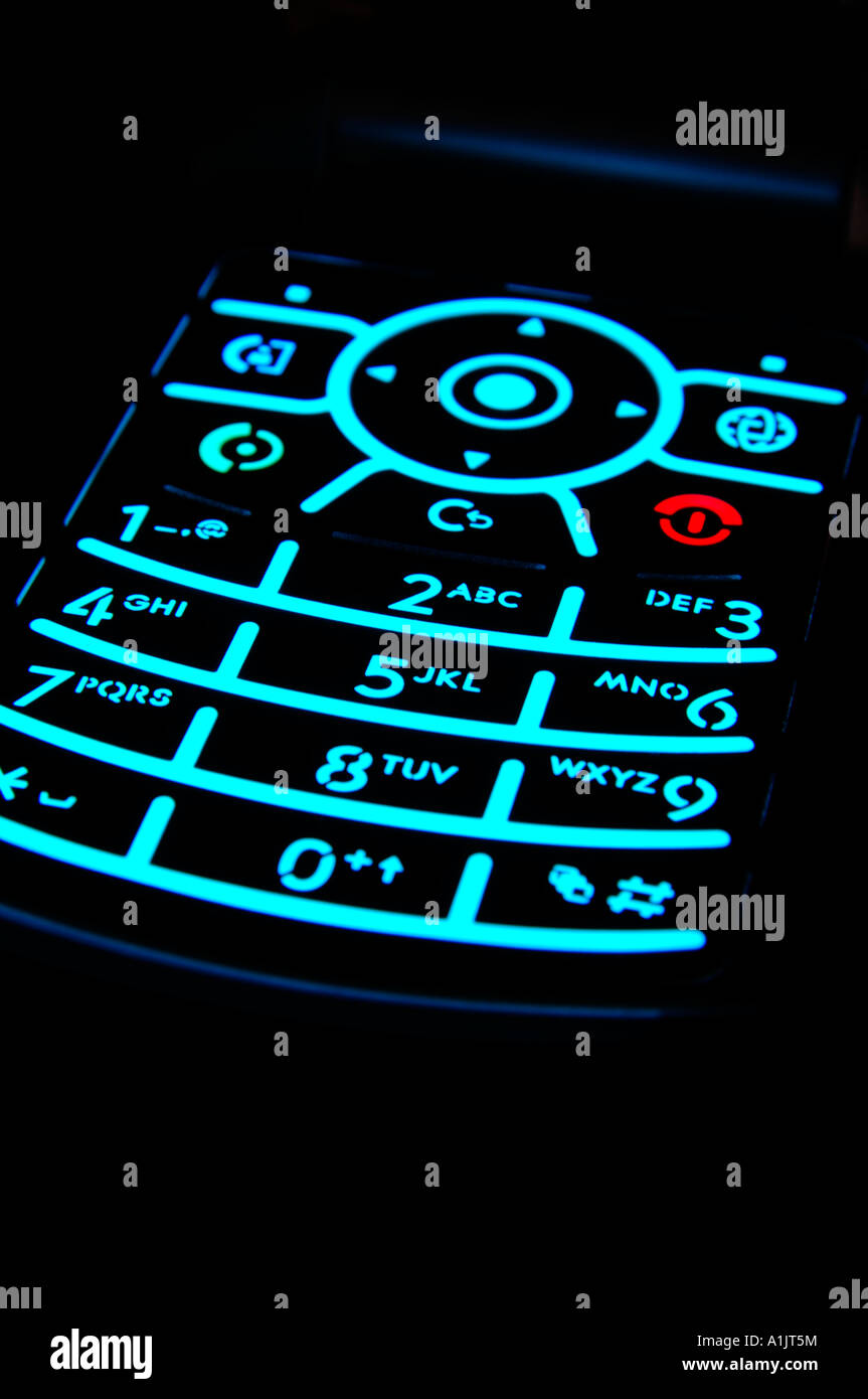 Illuminated keypad of modern mobile phone againt a black background ...