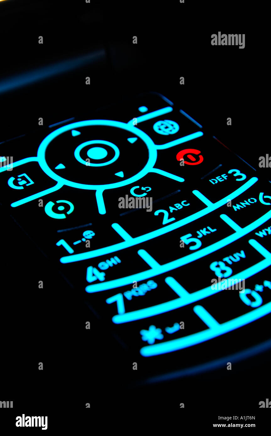 Illuminated keypad of modern mobile phone againt a black background ...