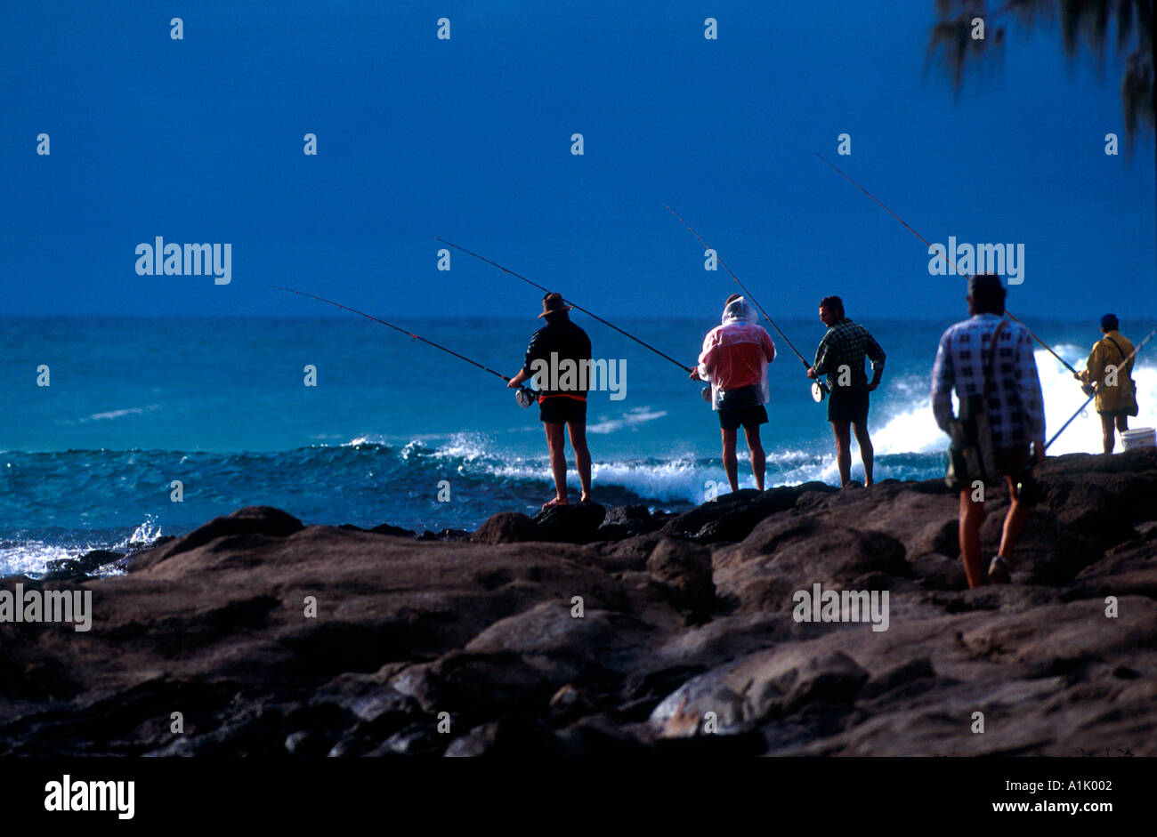 Anglers surf fishing from rocks Fraser Island Queensland Australia ...