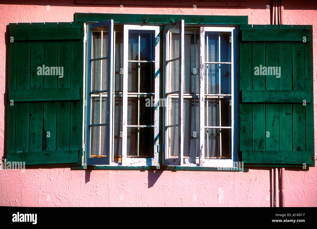Green shutter windows on pastel pink home New Providence Island Bahamas ...
