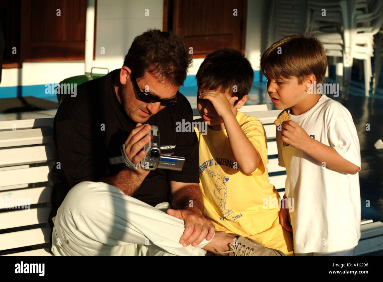 Father shows video camera recording to his two sons Stock Photo - Alamy
