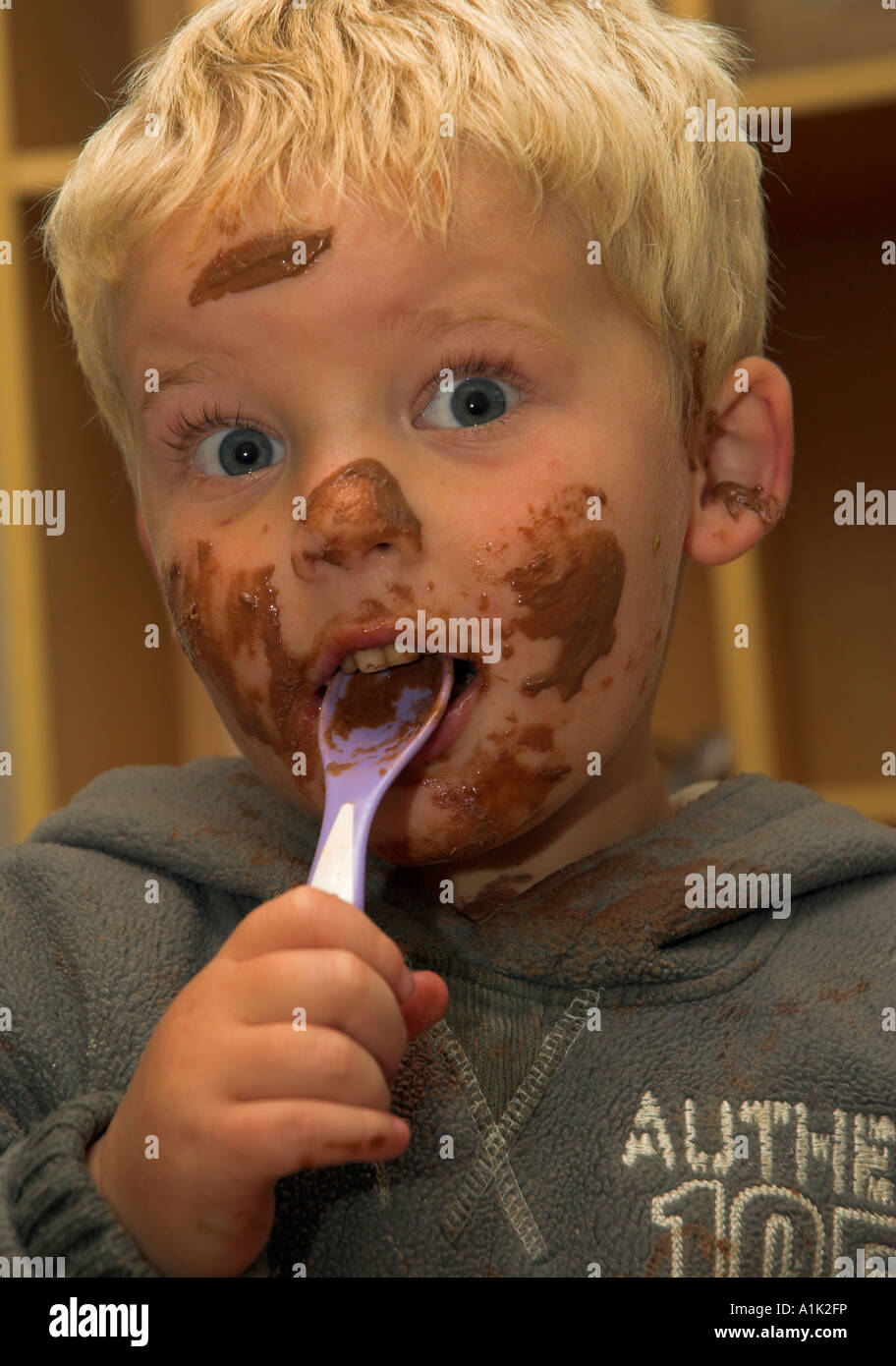 Kids in the kitchen pinching chocolate cake mix. Chocolate face Stock ...