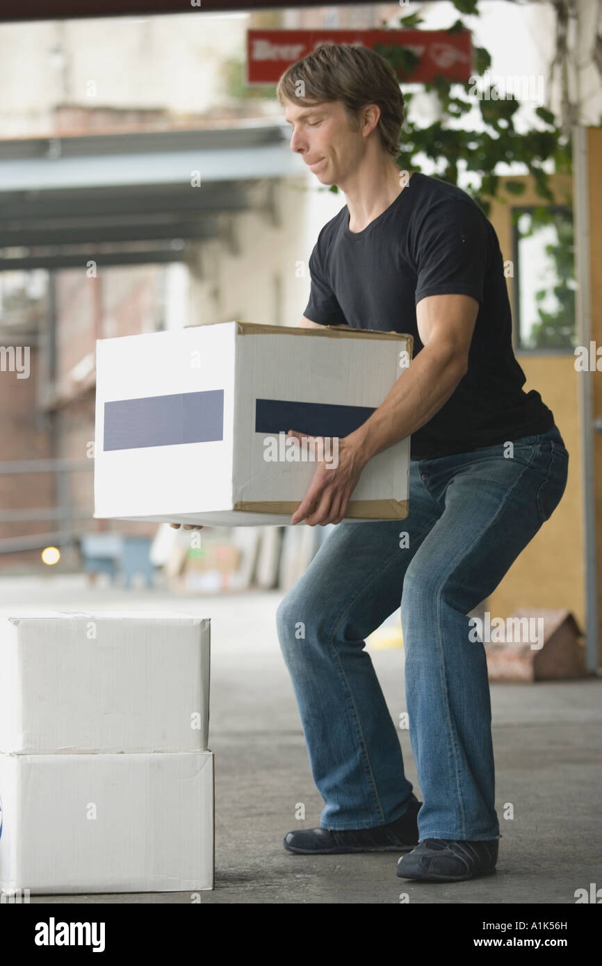 A caucasian male works lifts boxes Stock Photo - Alamy