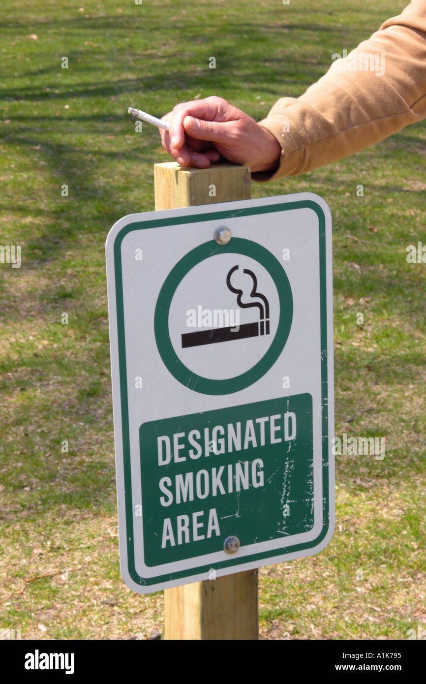 Male smokes cigarette in a designated outside area Stock Photo - Alamy