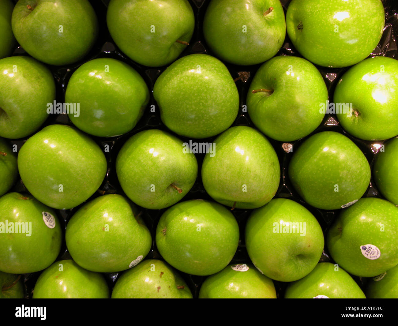 A pattern of green produce apples on display Stock Photo - Alamy