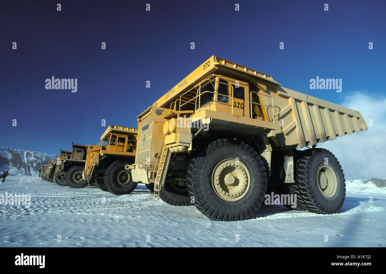ore hauling trucks in row at mine site in winter Stock Photo - Alamy