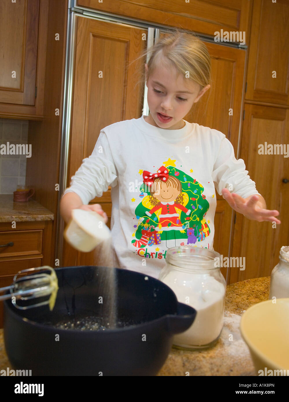 Child adding ingredients to a mixing bowl Stock Photo - Alamy