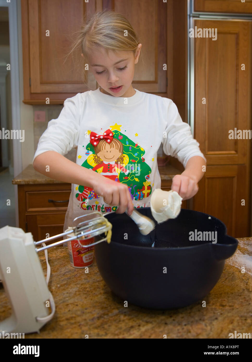 Child adding ingredient to a recipe Stock Photo - Alamy