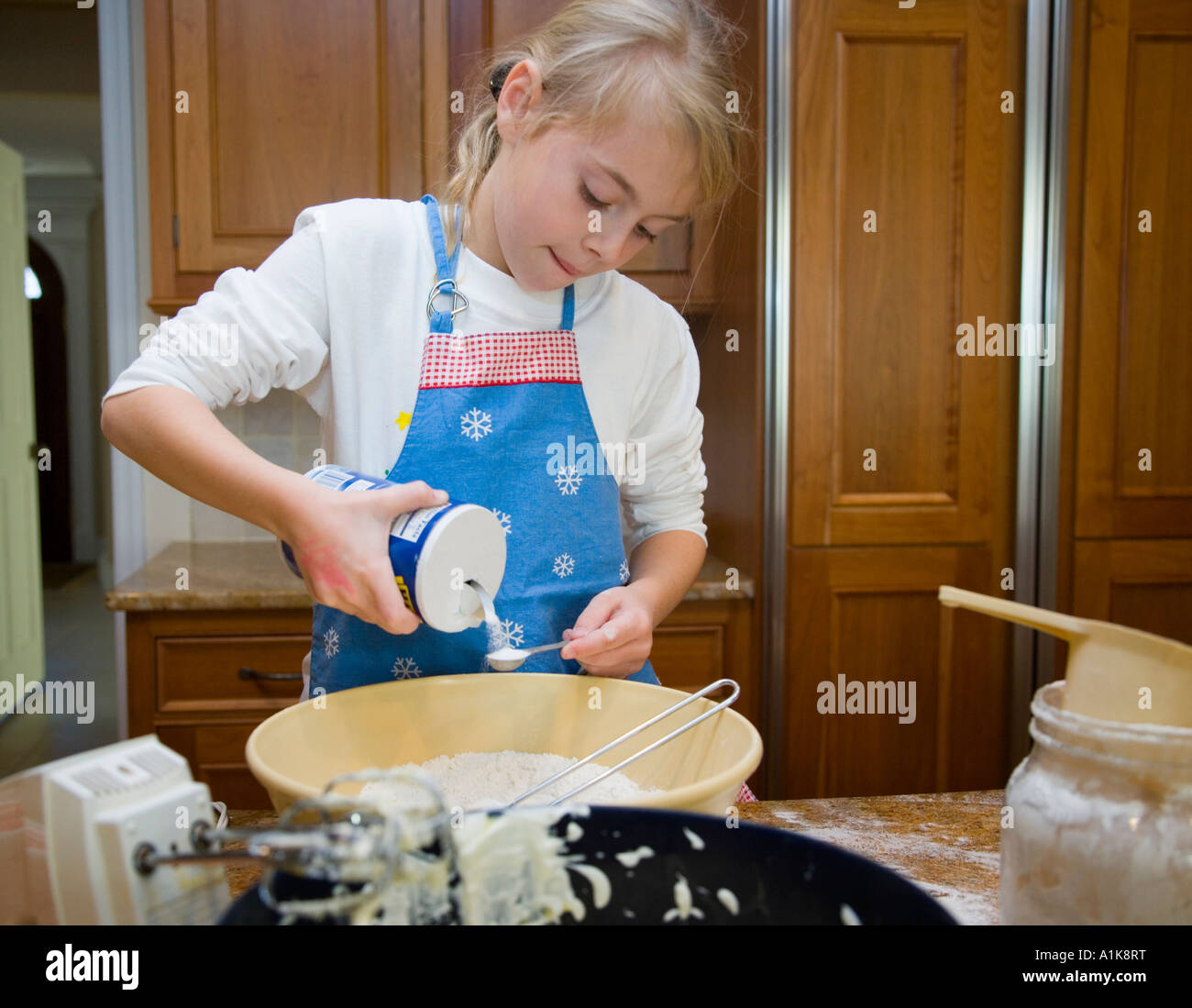 Child adding salt to a recipe Stock Photo - Alamy