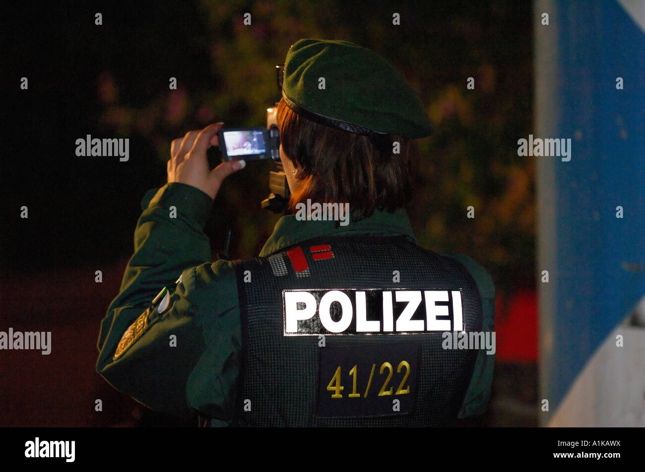 Bright letters on a police jacket, police woman doing video monitoring ...