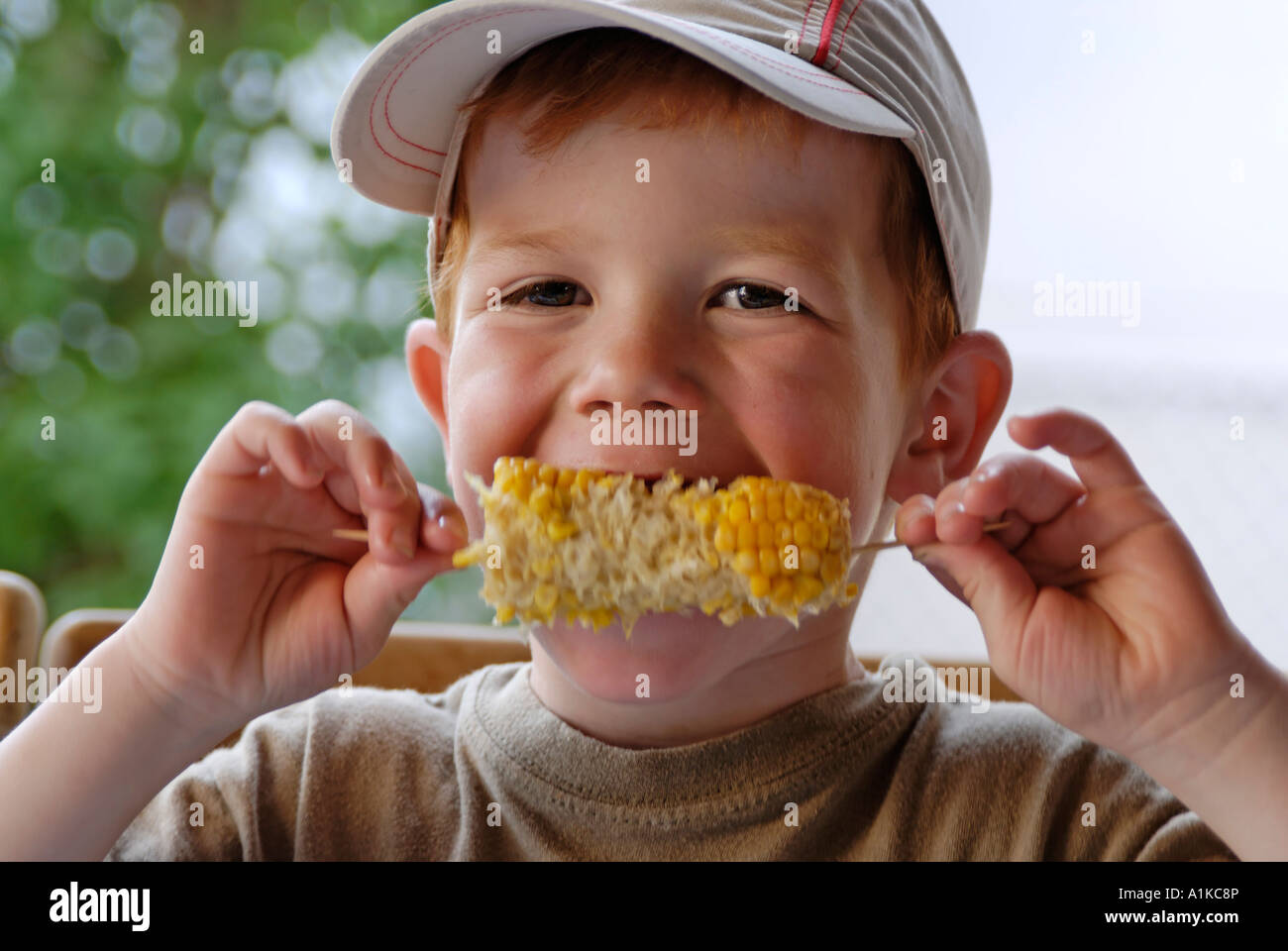 Little boy is eating a barbecue corn cob Stock Photo - Alamy
