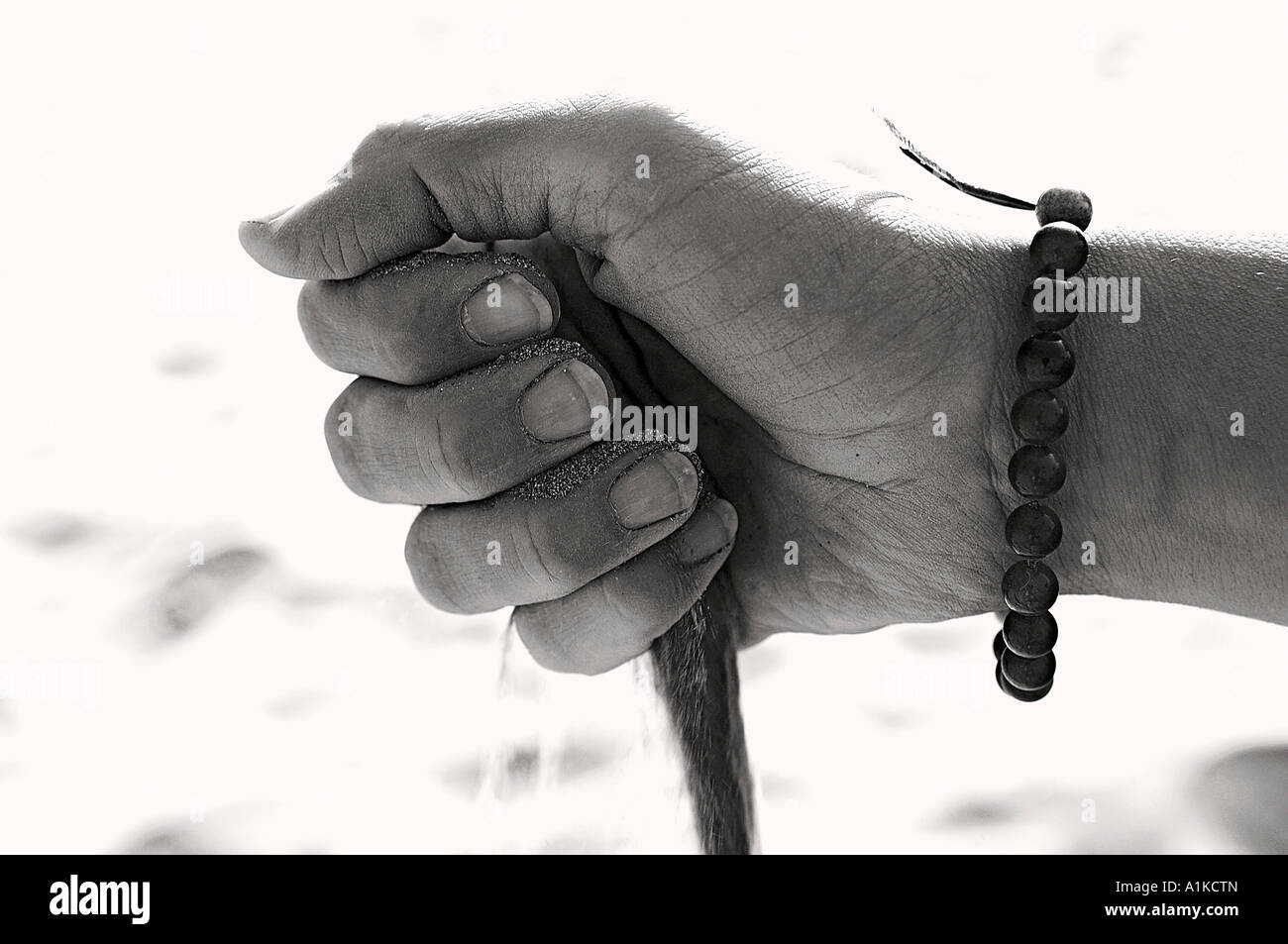 Sand pouring through a slightely opened fist Stock Photo - Alamy