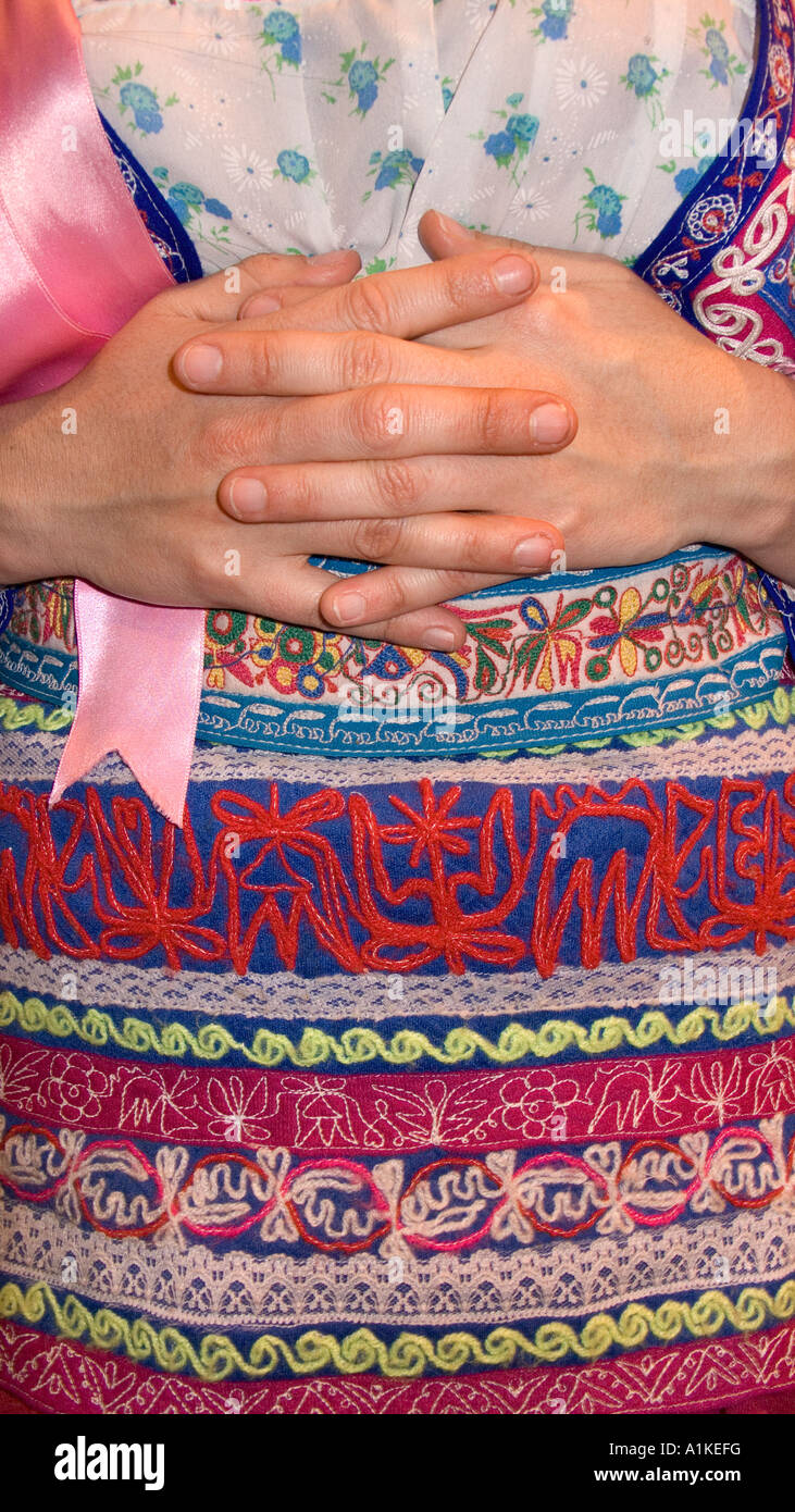 Detail of a Peruvian woman in traditional embroidered costume hands ...