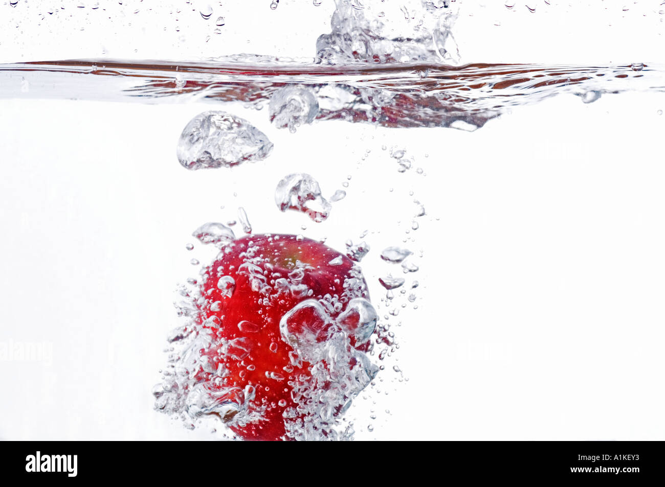 apple fruit dropped into water making splash Stock Photo - Alamy