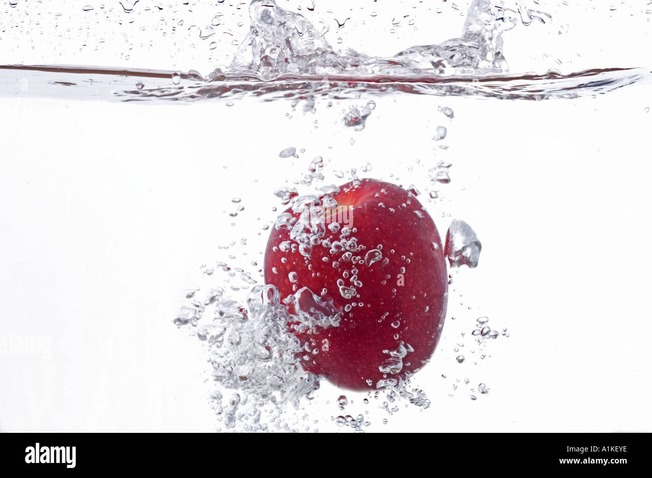 apple fruit dropped into water making splash Stock Photo - Alamy