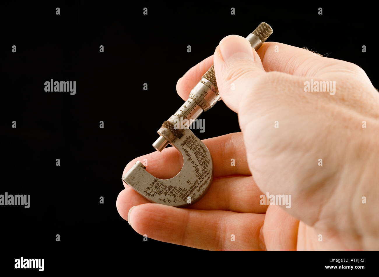 hand with micrometer instrument for precise measurement in engineering ...