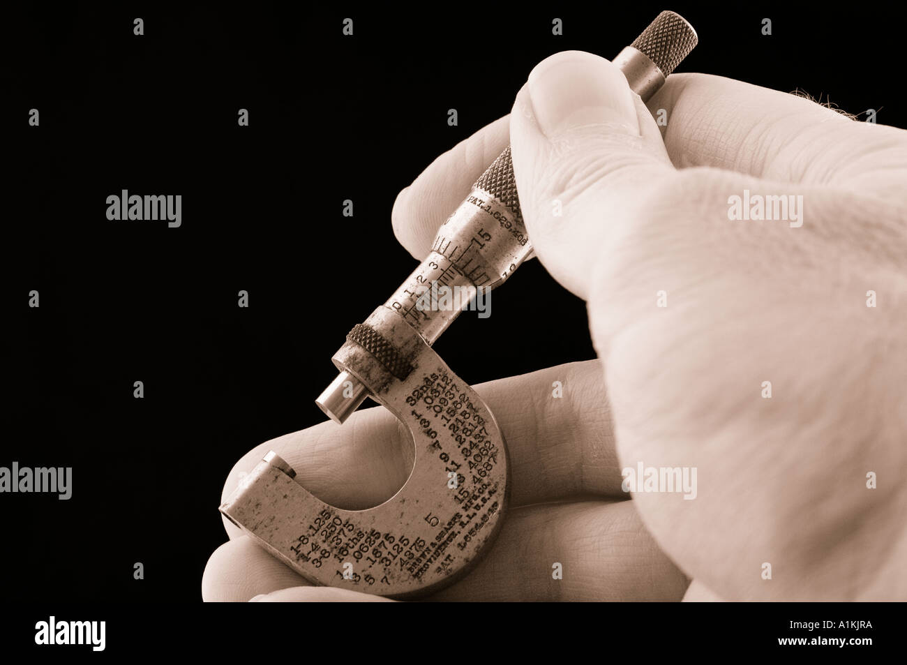 hand with micrometer instrument for precise measurement in engineering ...