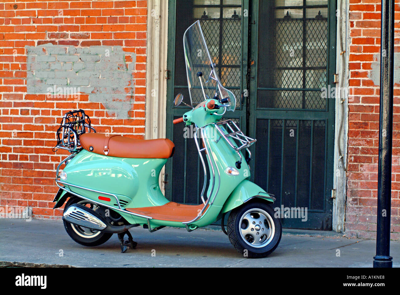 Green Vespa motorcycle parked on street Stock Photo - Alamy