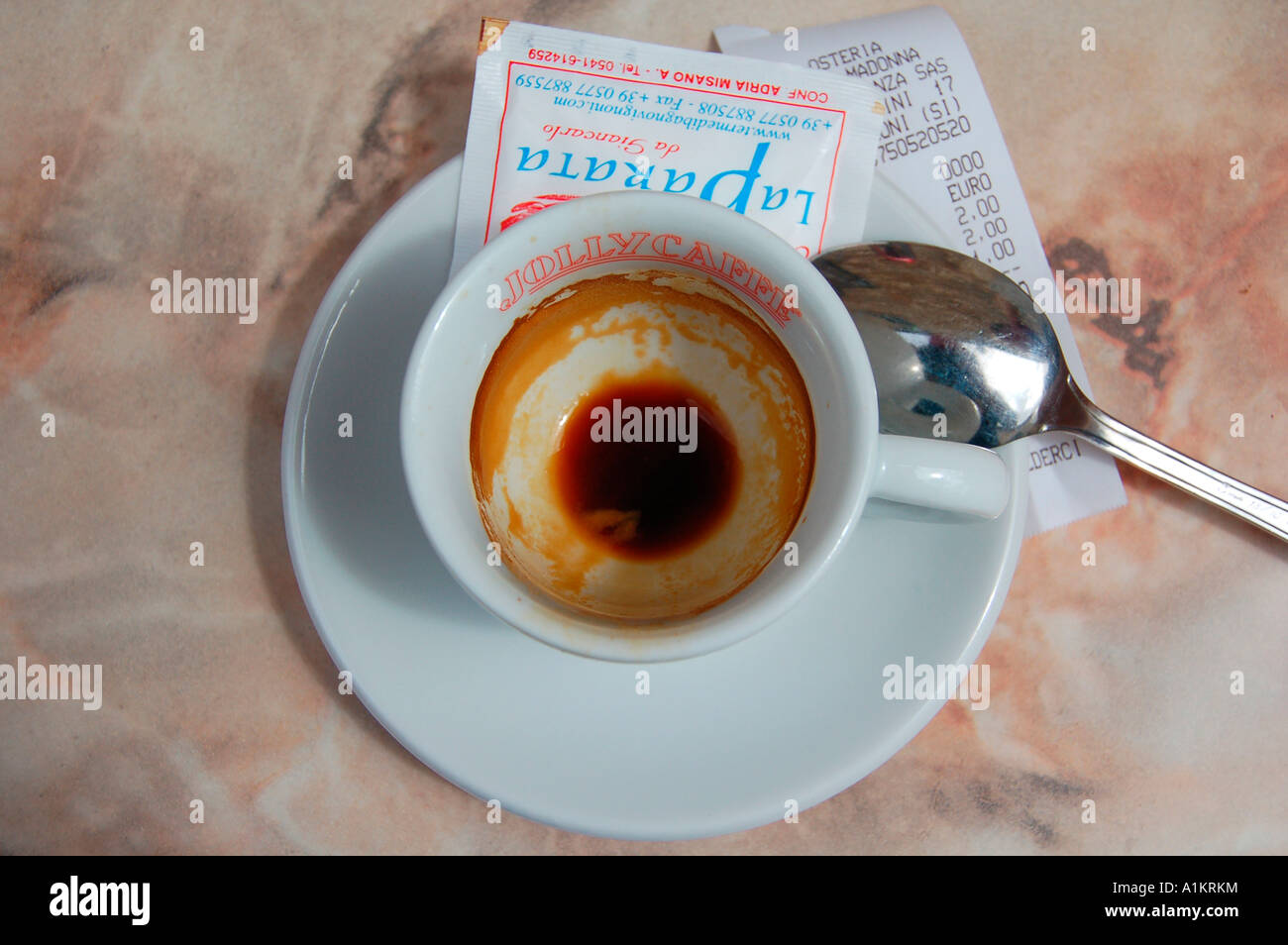 Empty cup of coffee with a packet of sugar and the bill as seen from ...