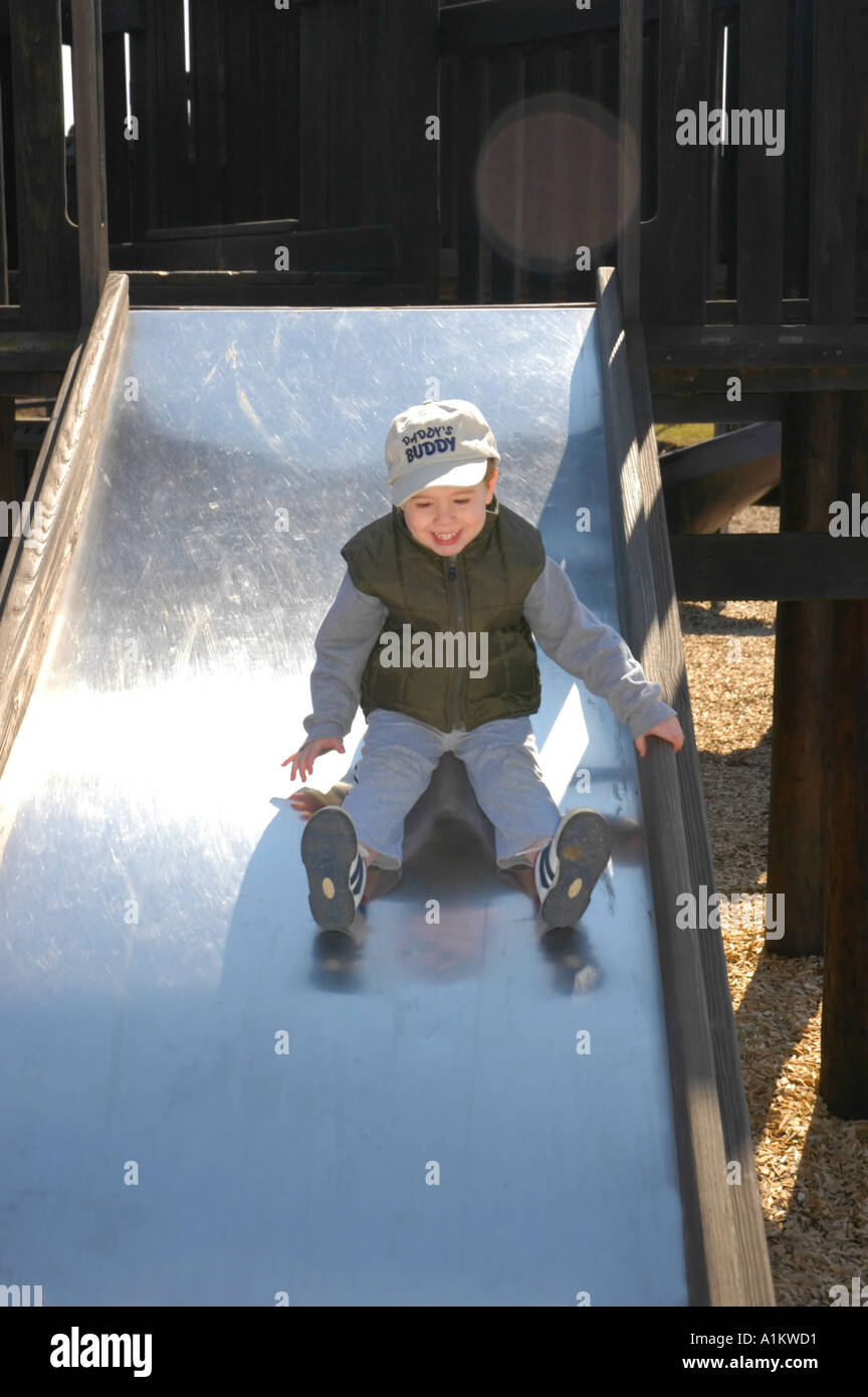 Young three year old smiling boy on a playground slide Stock Photo - Alamy