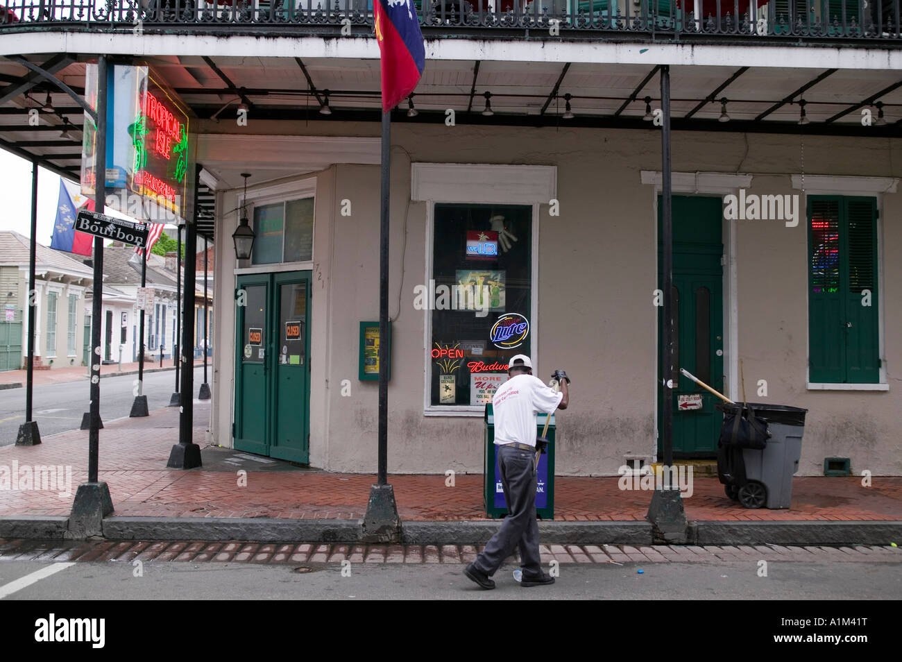 A man sweeping the street clean early morning on Bourbon Street in the ...
