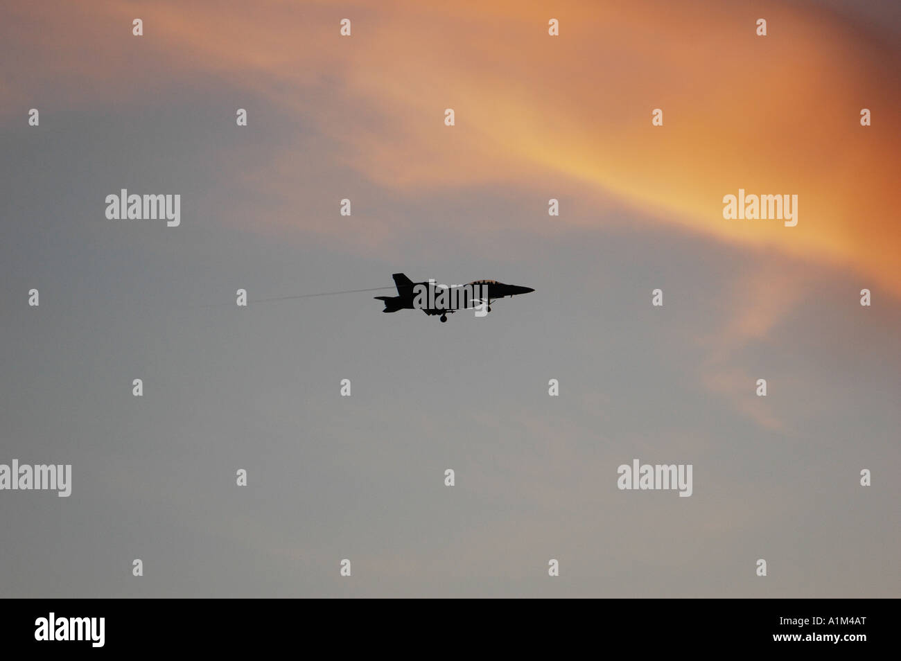 Fighter jet flying through a sunset Stock Photo - Alamy
