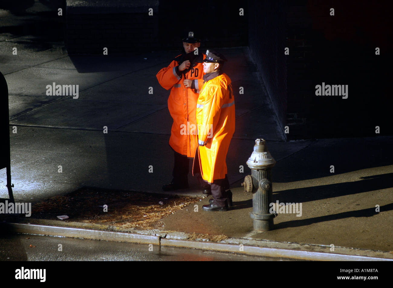 Two NYPD officers in orange rain slickers on duty on Ninth Ave in ...