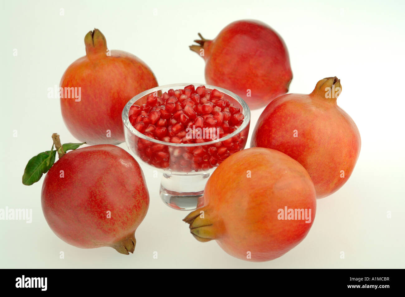 Pomegranate fruit and seeds in glass cup with white background Stock ...