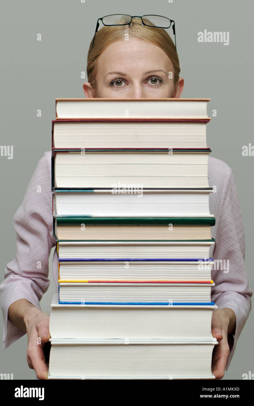Woman Carrying a Big Stack of Books Stock Photo - Alamy