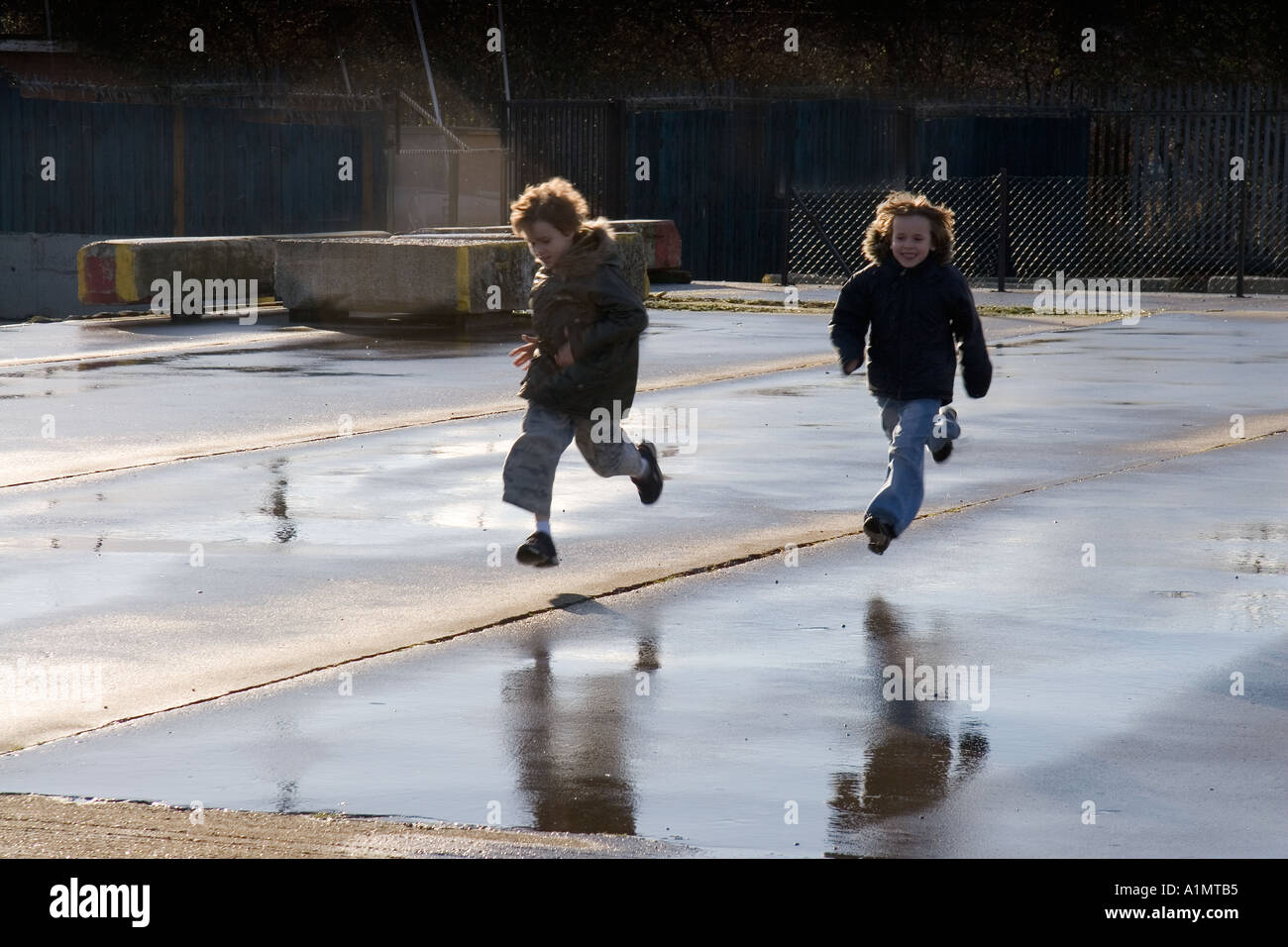 Two boys running in empty urban setting Stock Photo - Alamy