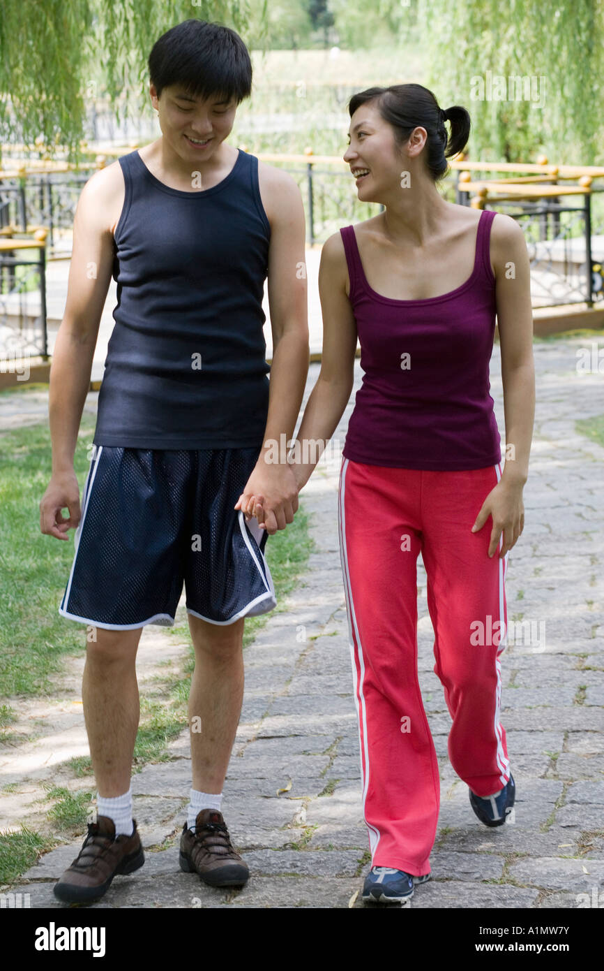 Young couple walking together in a park Stock Photo - Alamy