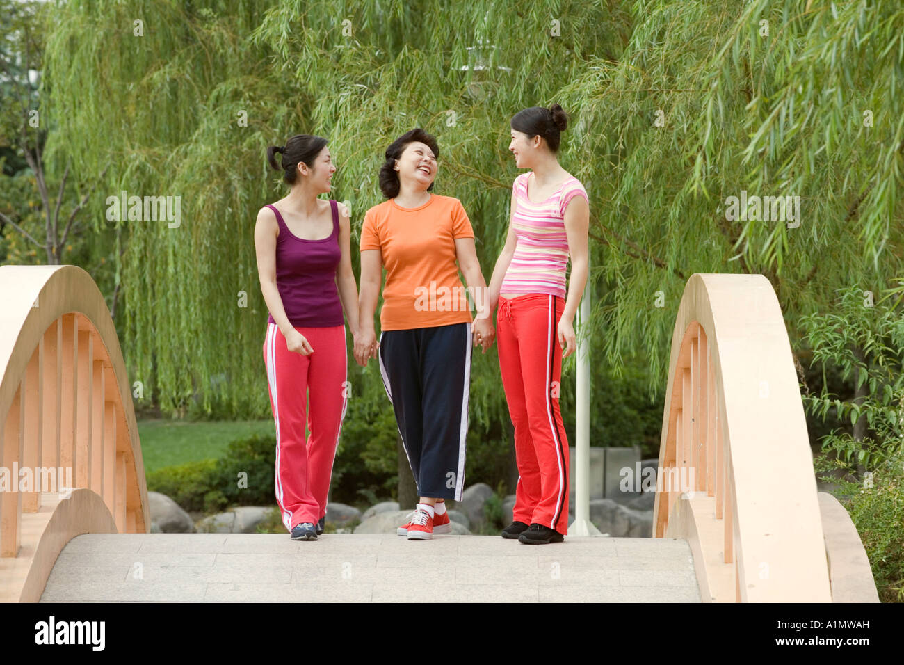 Mother and daughters walking over a bridge Stock Photo - Alamy