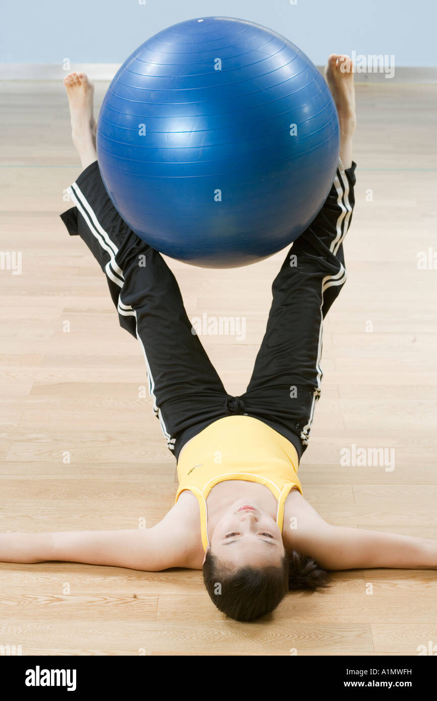 Young woman holding an exercise ball between her ankles Stock Photo - Alamy