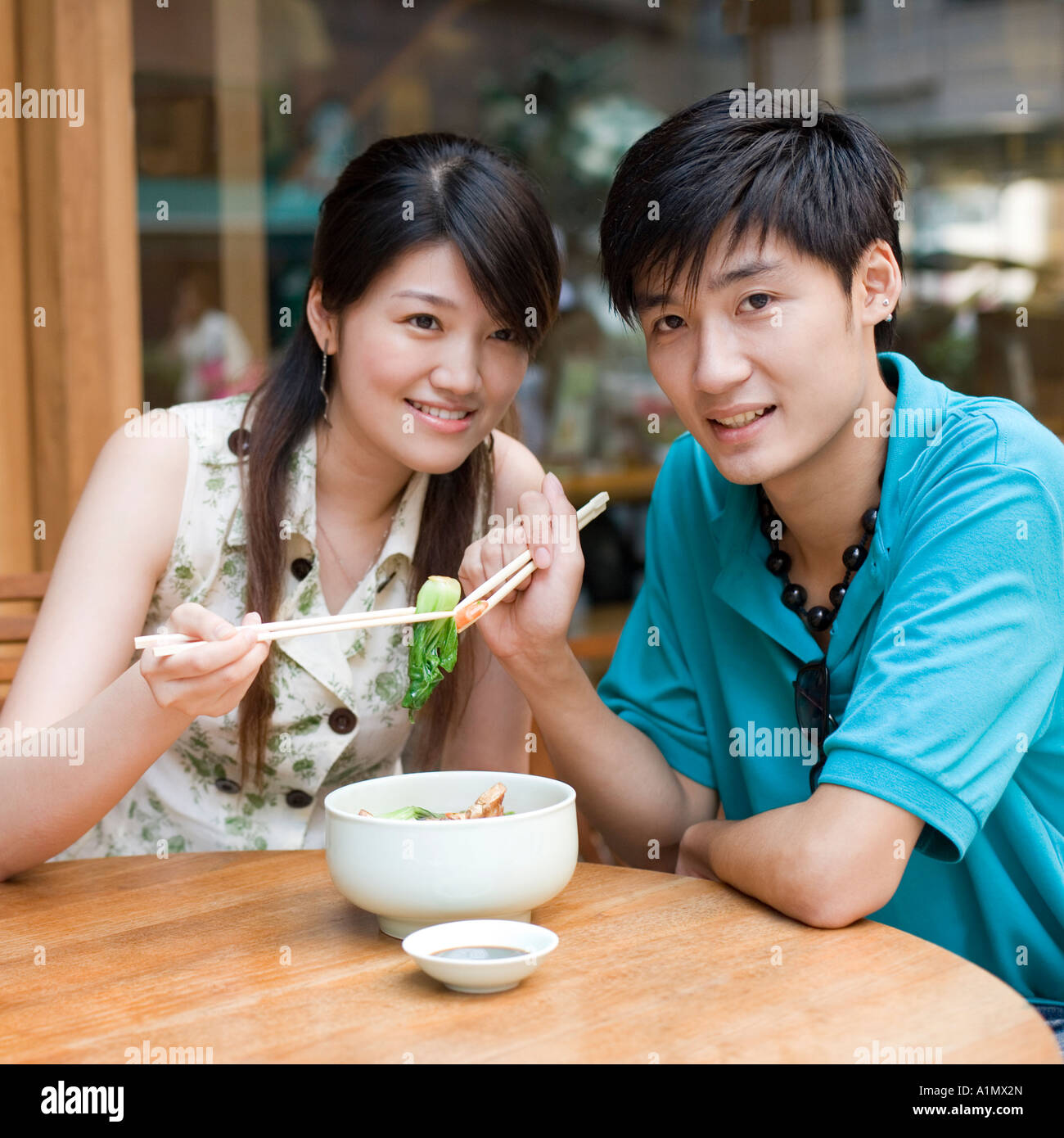 Young couple sharing noodles Stock Photo - Alamy