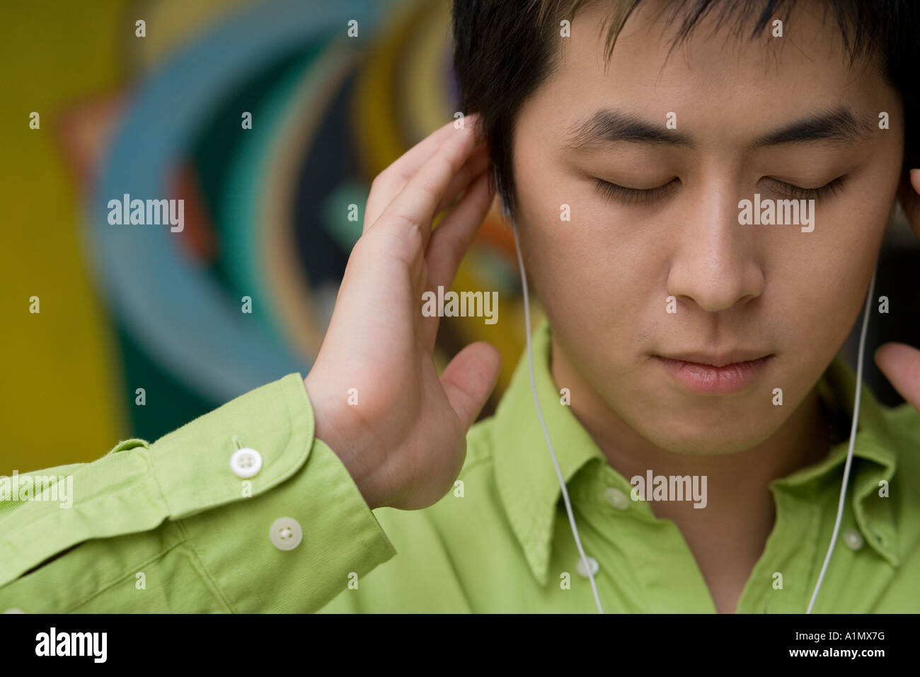 Young man listening to headphones Stock Photo - Alamy