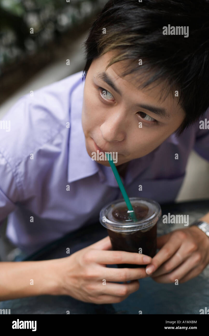 Young man drinking soda Stock Photo - Alamy