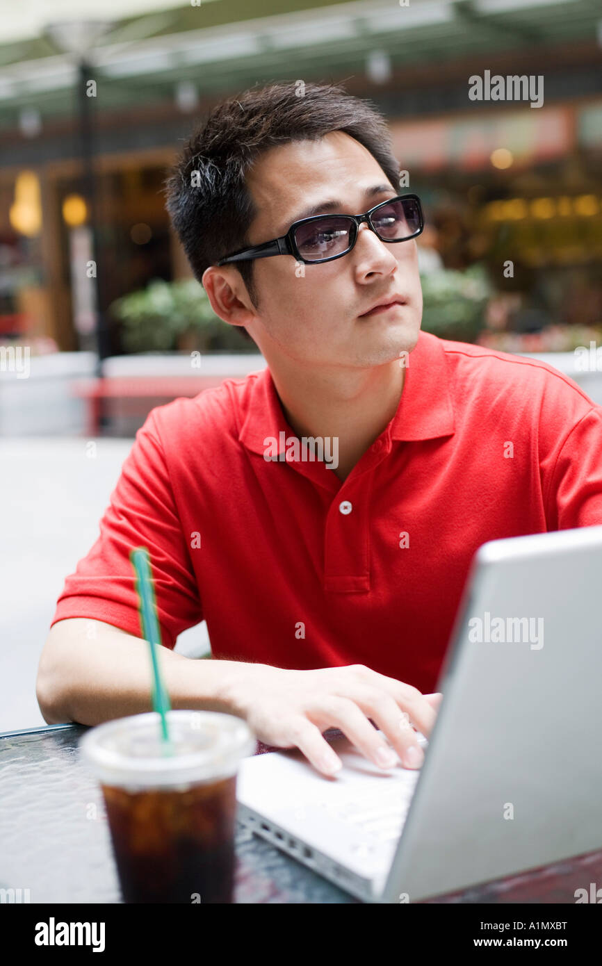 Young man using a laptop Stock Photo - Alamy