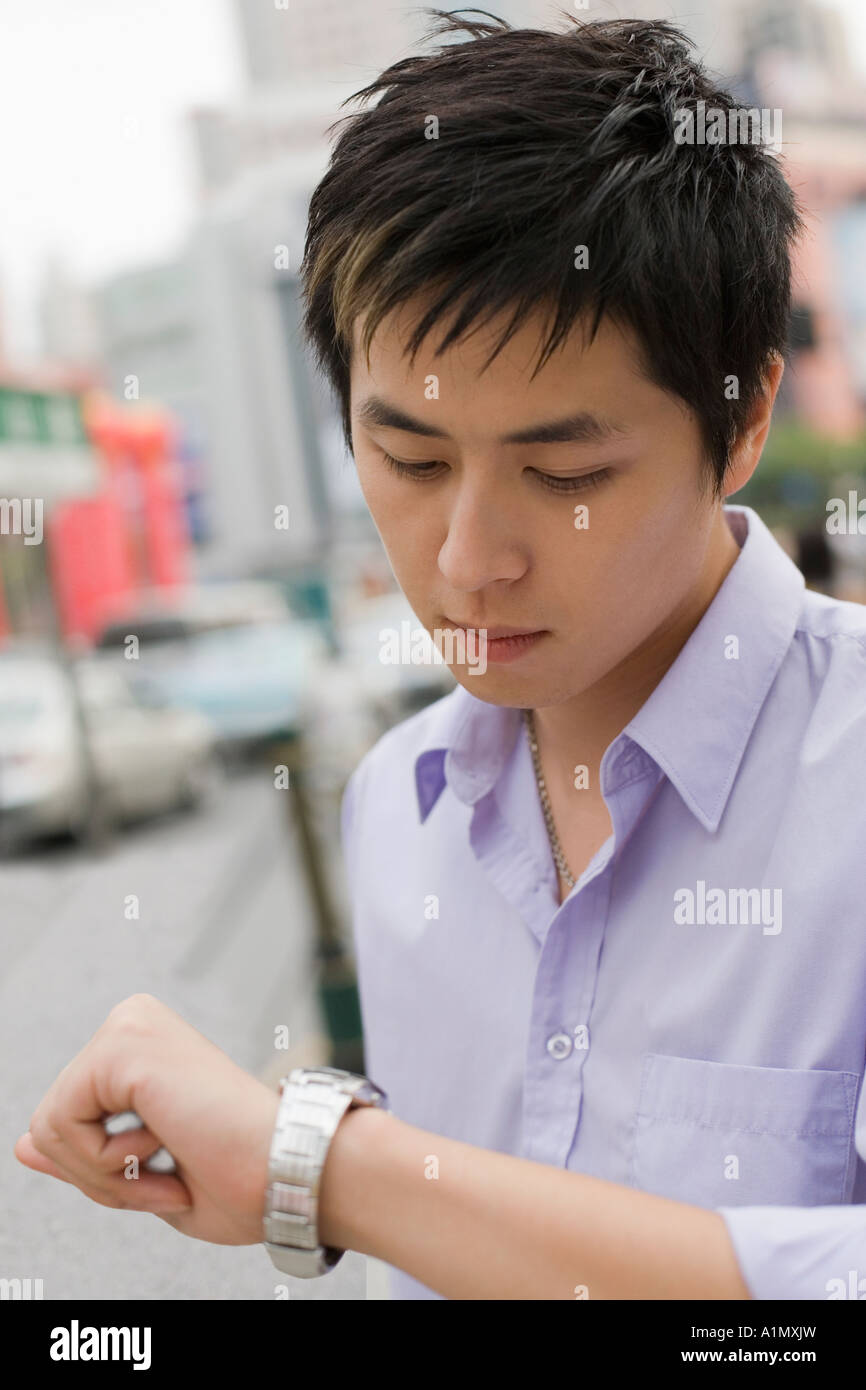 Young man checking his watch Stock Photo - Alamy