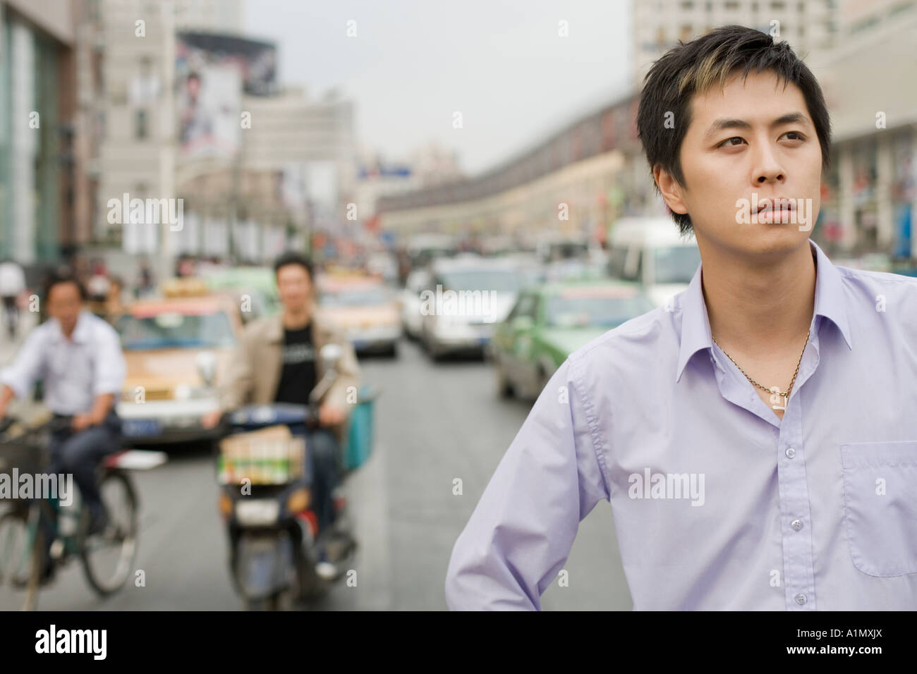 Young man standing on urban street Stock Photo - Alamy
