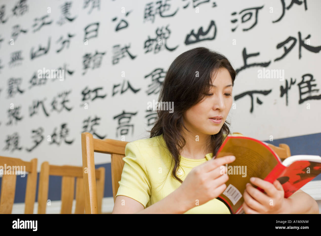 Young woman reading indoors Stock Photo - Alamy