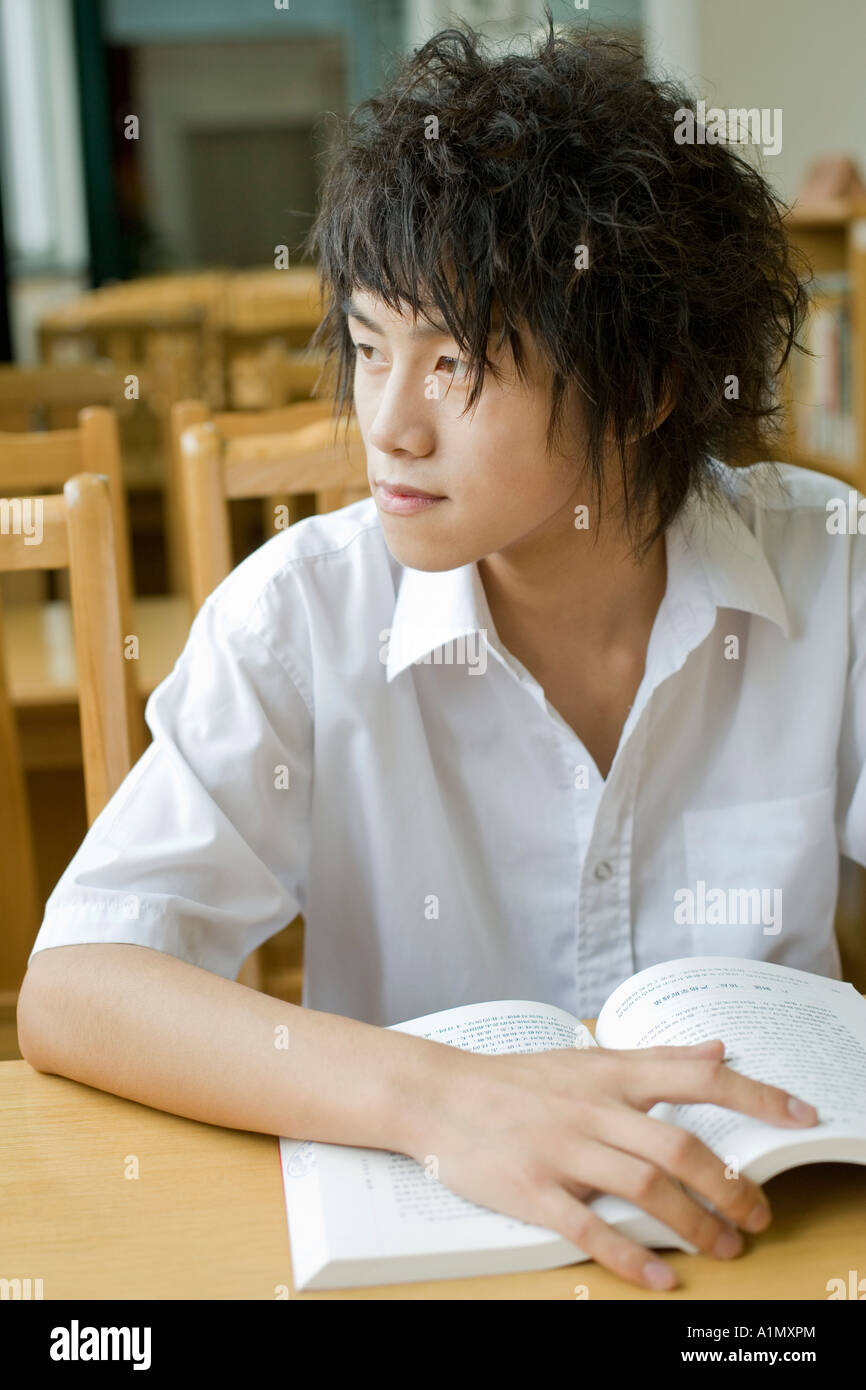 Young man reading indoors Stock Photo - Alamy