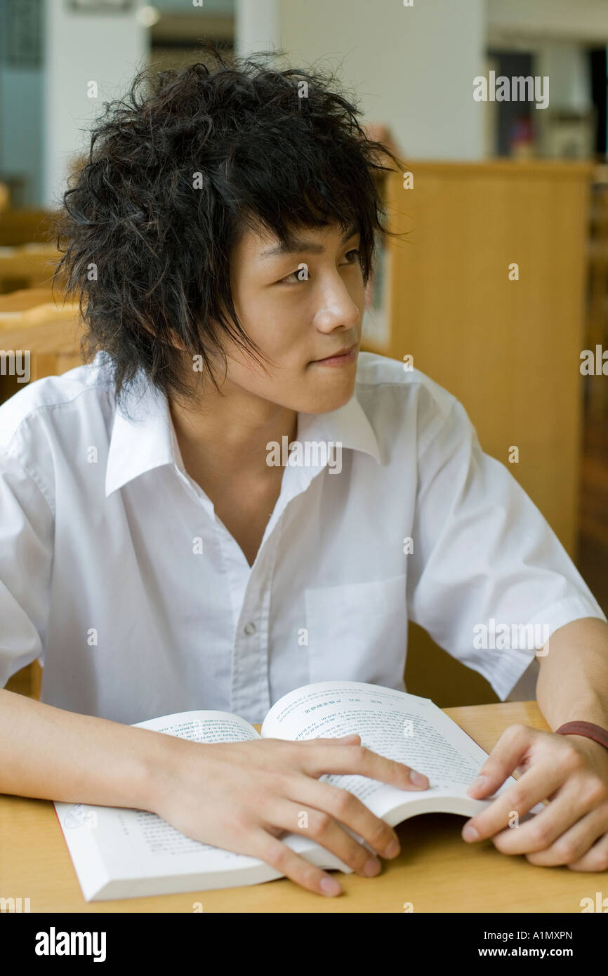 Young man reading indoors Stock Photo - Alamy